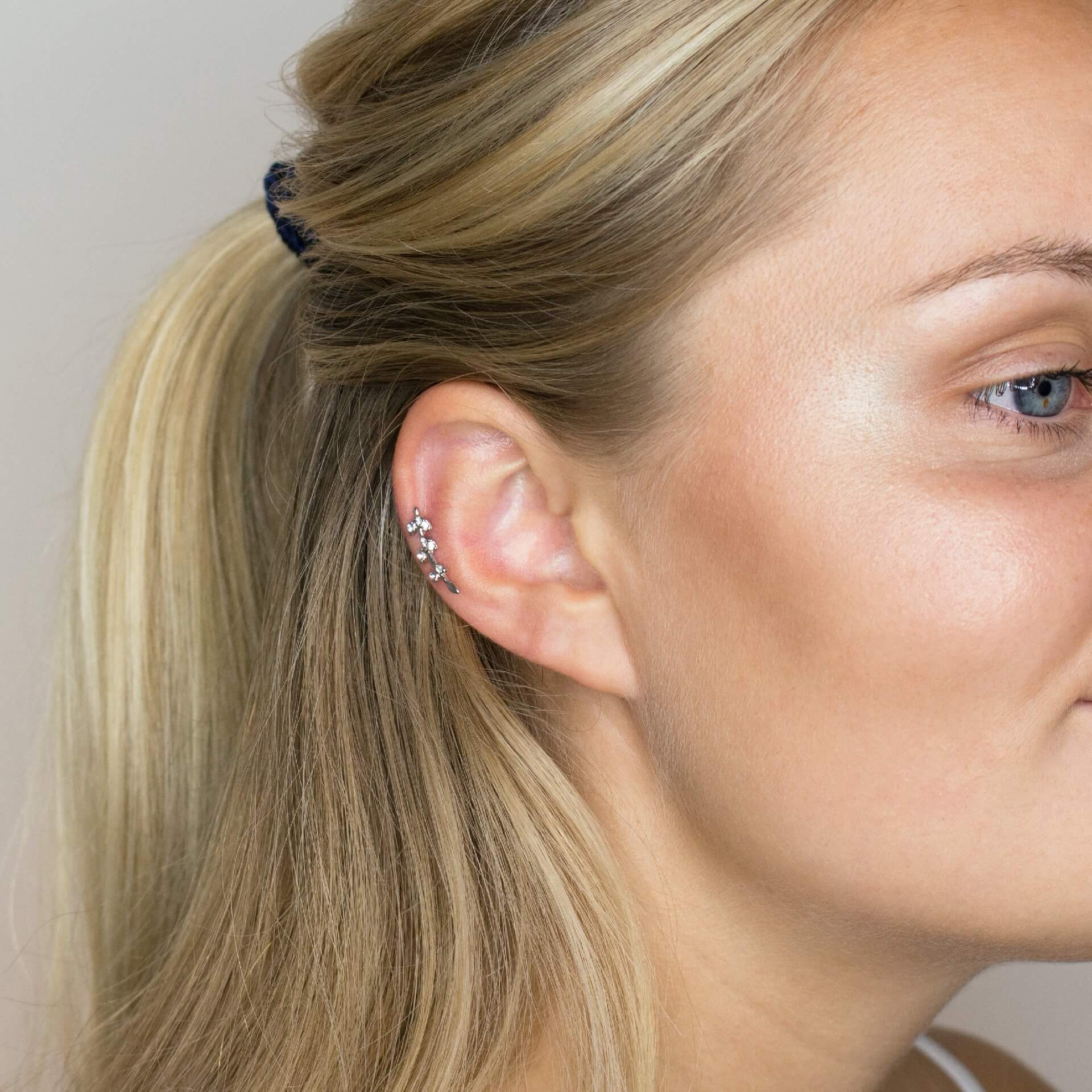 Feines und glänzendes Ohrpiercing mit Steinen in verschiedenen Farben